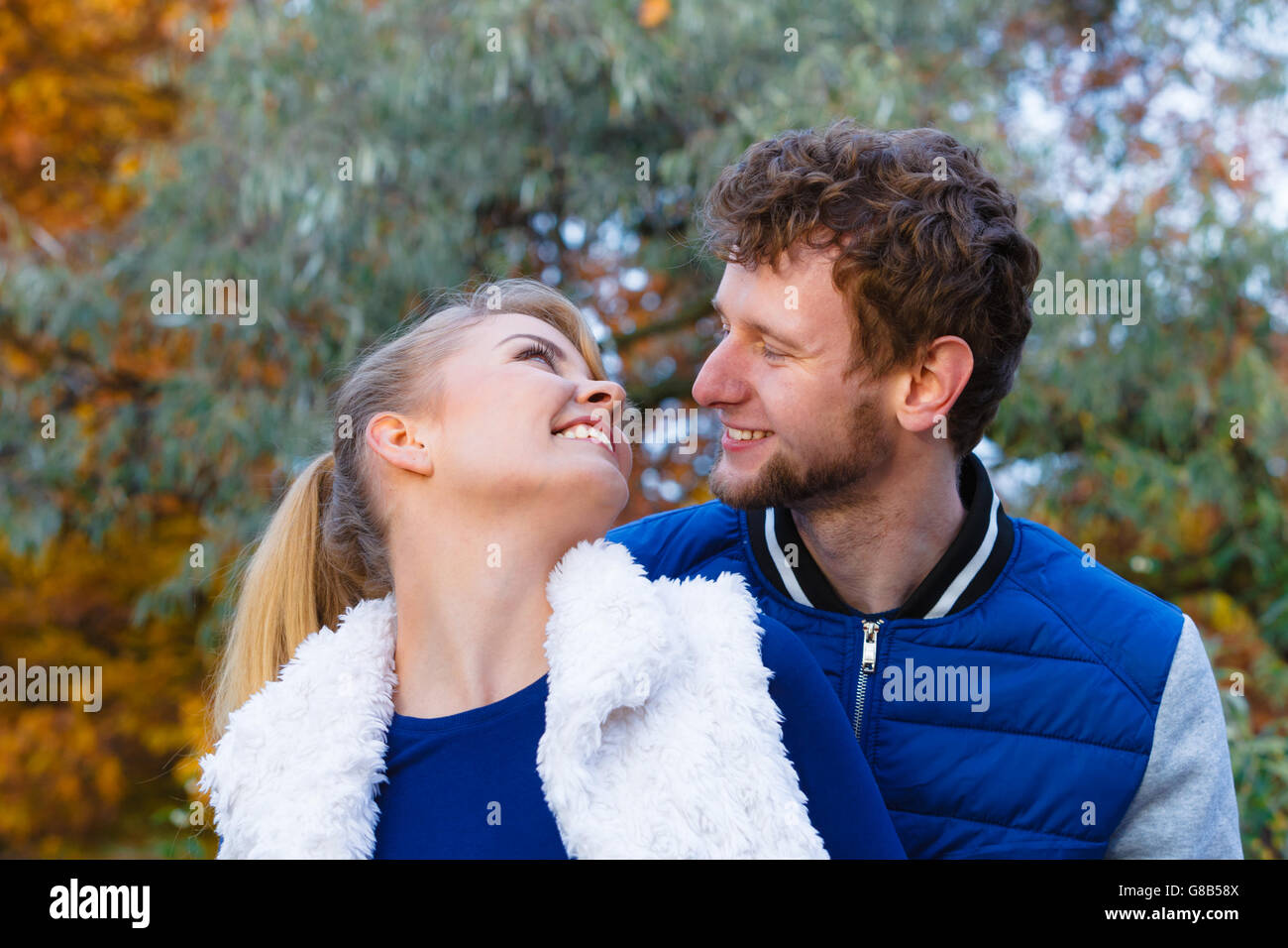 Season, happiness and people concept. Young romantic couple relaxing in ...