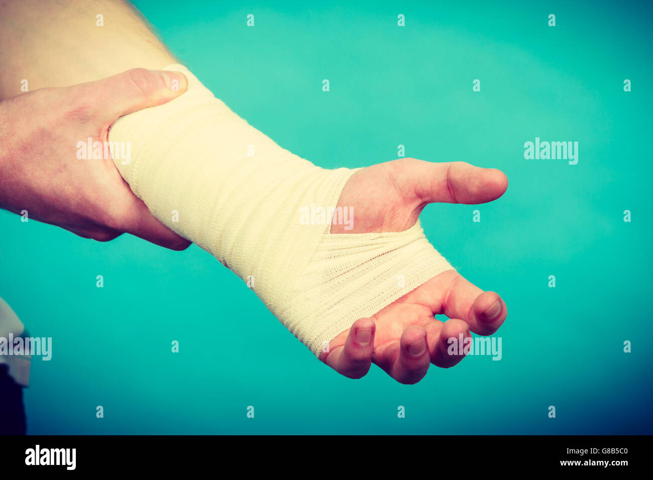 Pain and injury concept. Young man holds bandaged hand. Injured part of ...