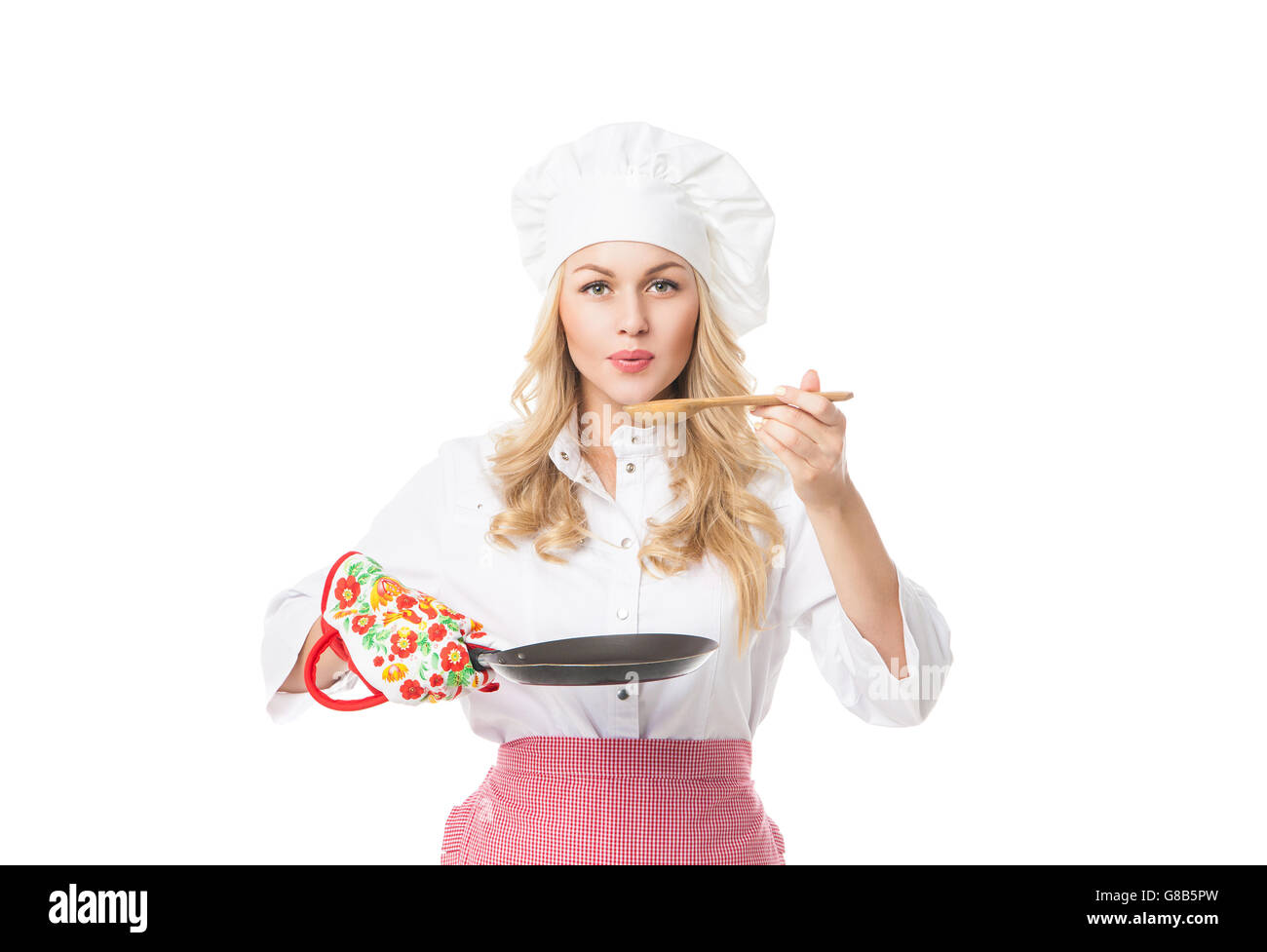Portrait of beautiful young woman with frying pan blowing on wooden ...
