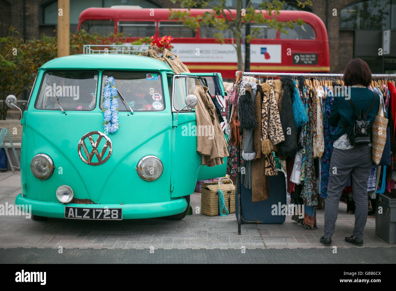 A visitor looks through vintage clothing next to a Volkswagen van at ...