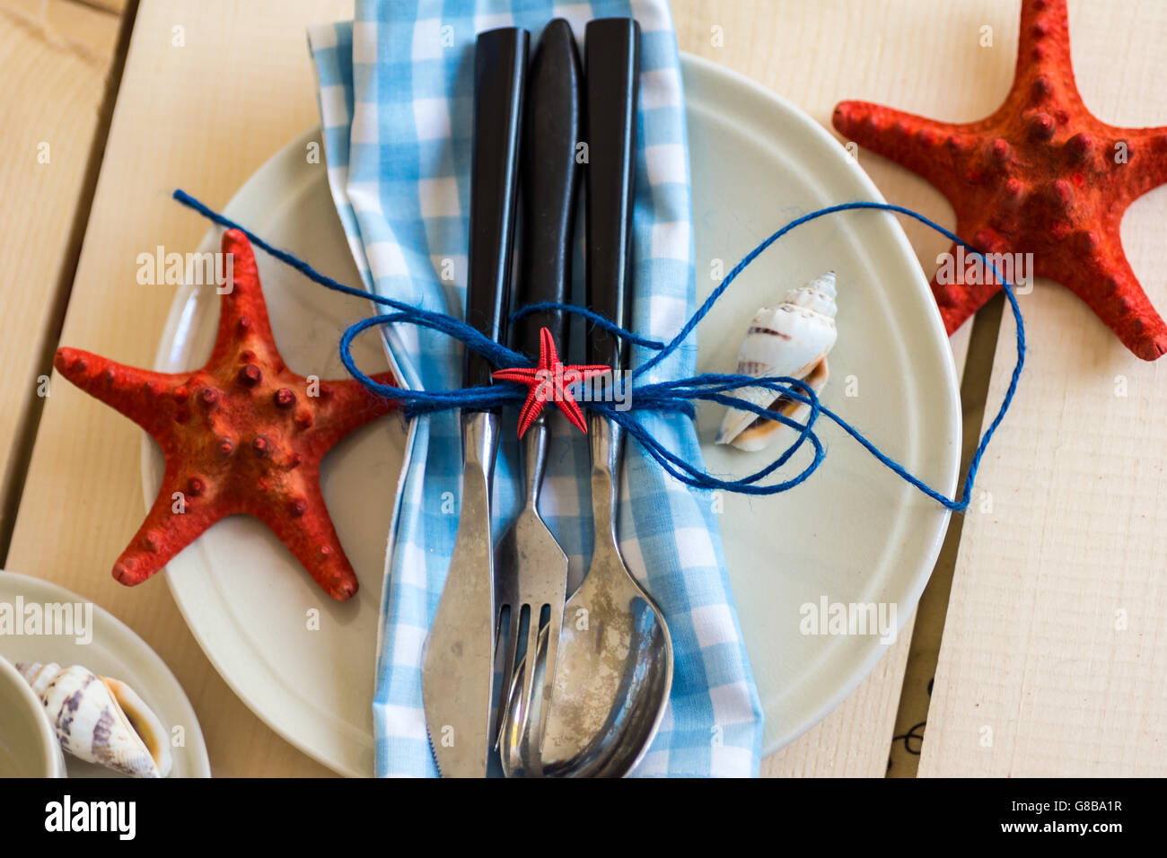 Rustic marine table setting with sea stars, vintage silverware and ...
