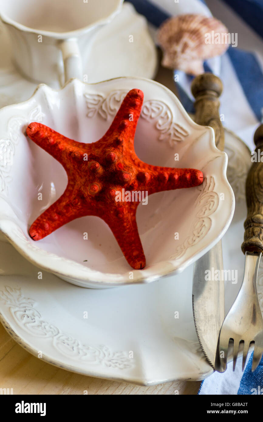 Rustic marine table setting with sea stars, vintage silverware and ...