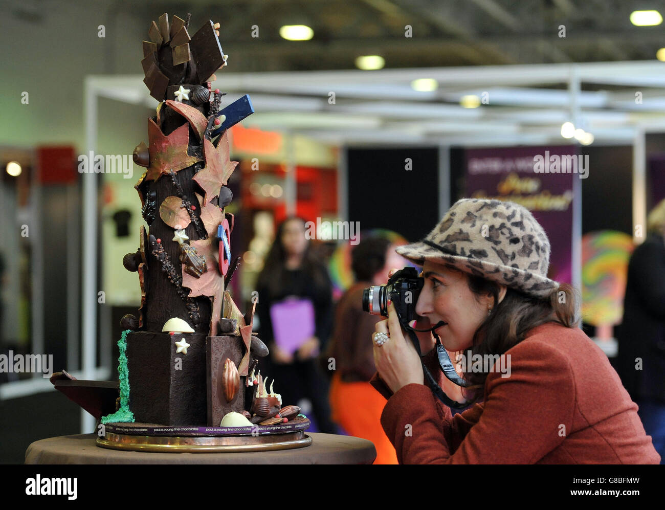 A woman takes a picture of a chocolate sculpture by chocolatier Paul. A ...