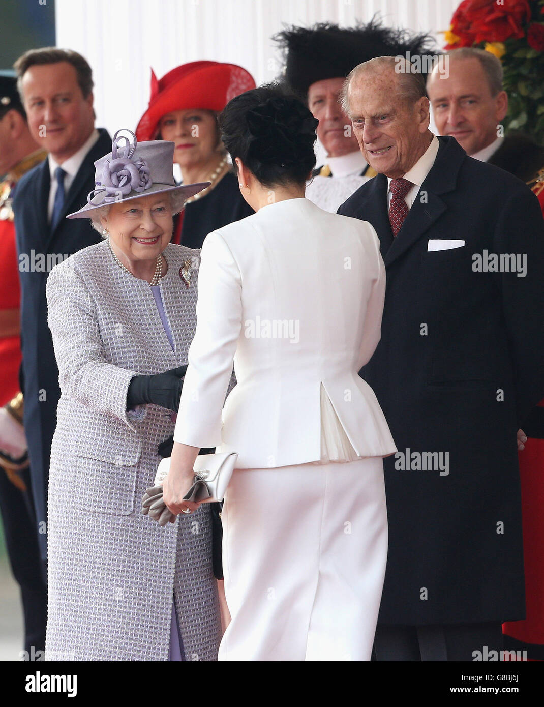 Queen Elizabeth II shakes hands with Madame Peng Liyuan as the Duke of ...