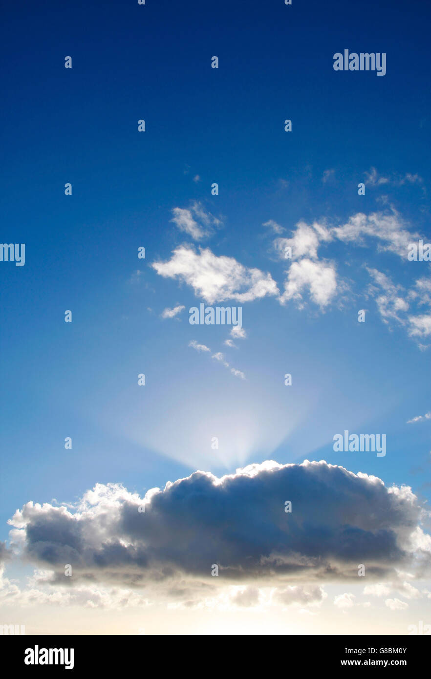 Sunlight behind a dark cloud, blue sky Stock Photo - Alamy