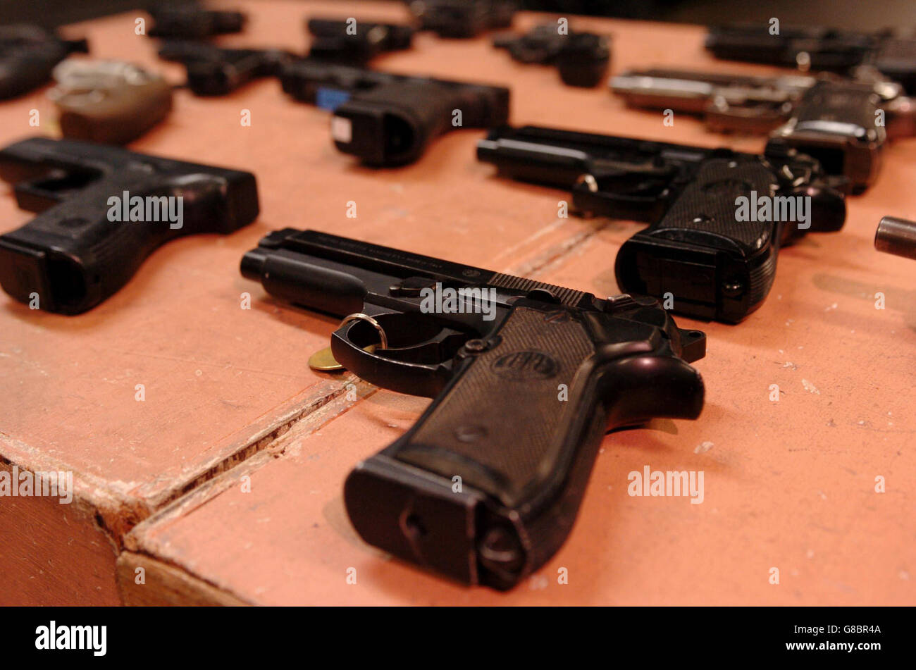 Imitation guns sit alongside real firearms during a press briefing. A ...
