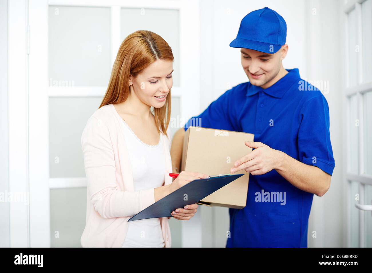 Young woman receiving parcel hi-res stock photography and images - Alamy