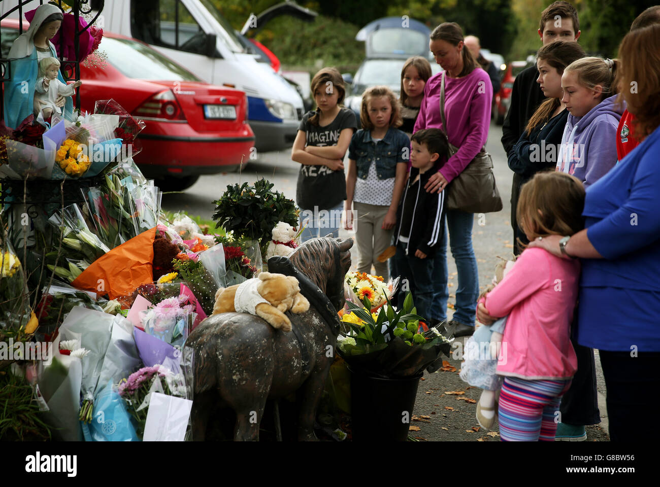 People gather as toys and flowers are left at a halting site for ...