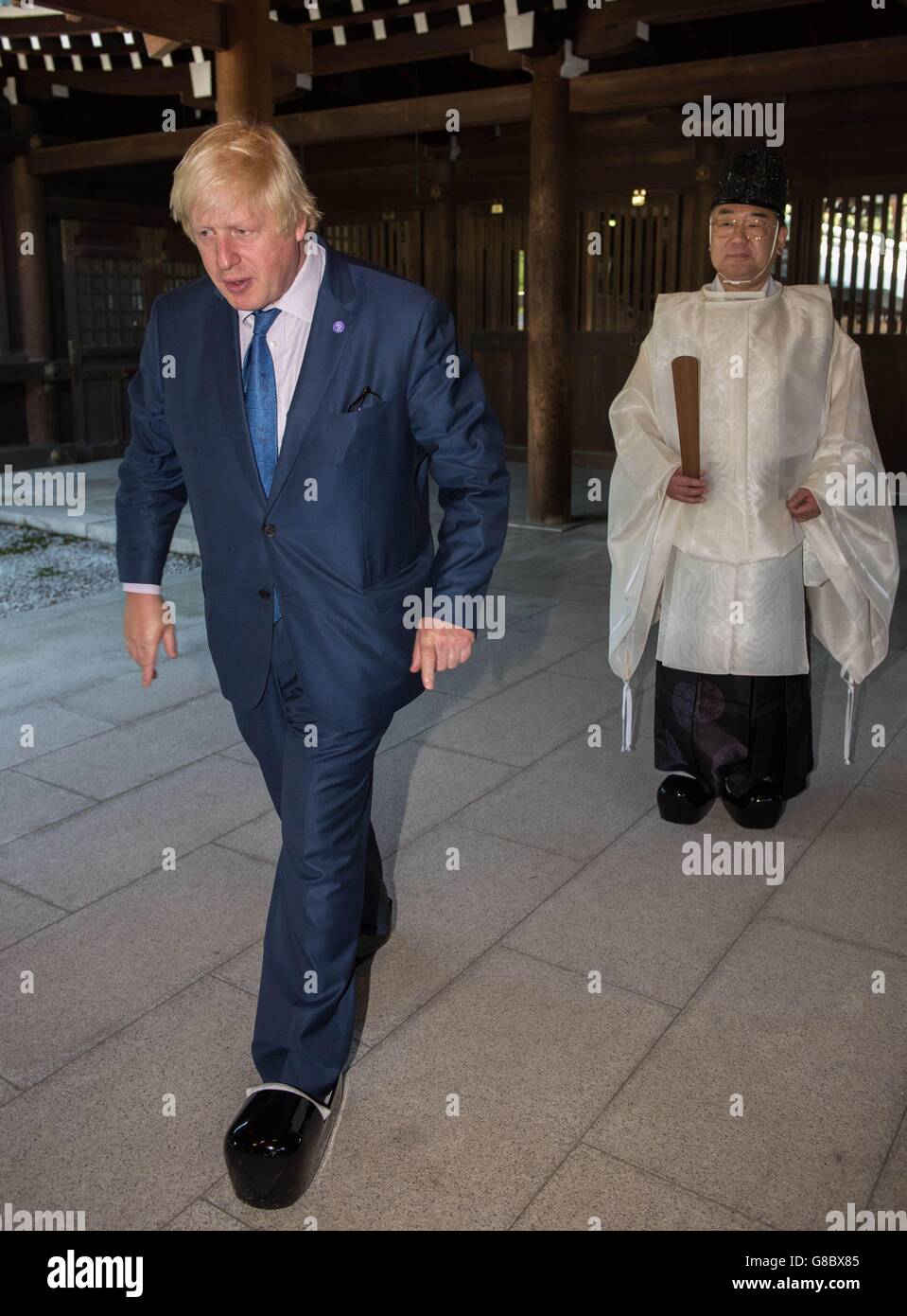 Mayor of London Boris Johnson, with Priest Hiroyasu Nukaga, tries on a ...