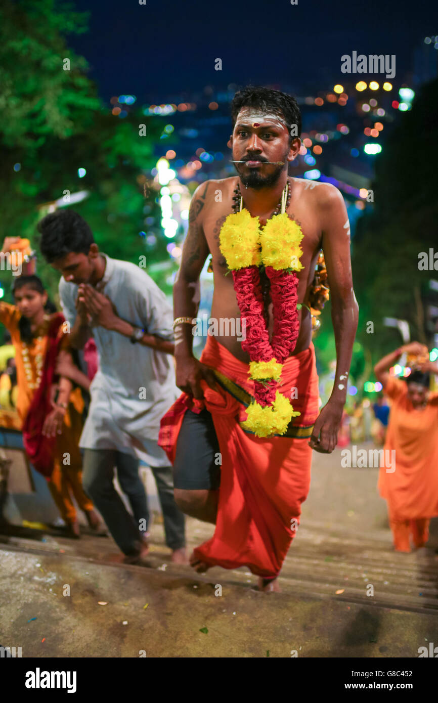Kavadi bearer with pierced mouth and milk pots fulfill his pilgrimage ...