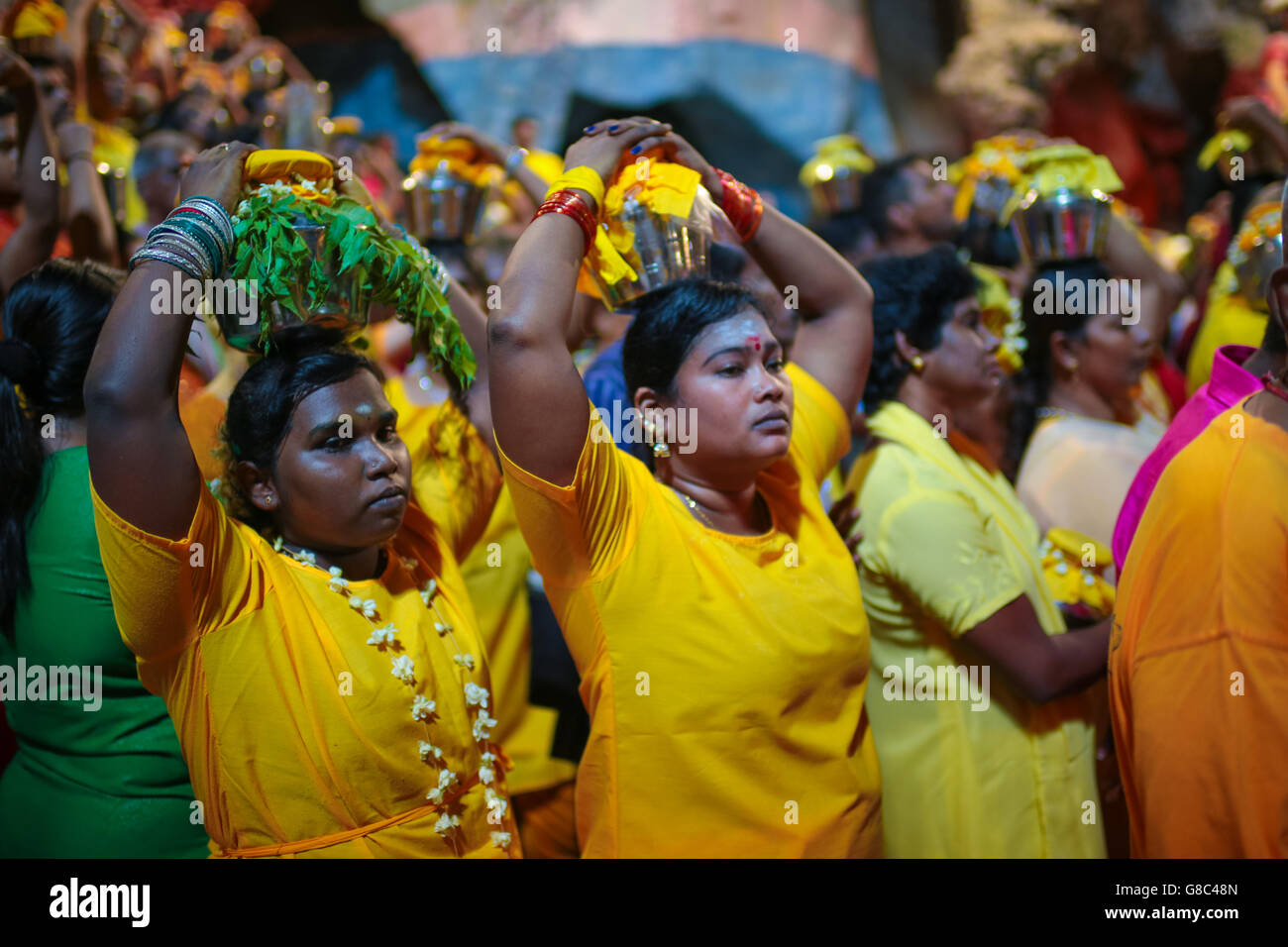 Hindu womans carrying milk pot waiting inside Batu Cave temple to give ...
