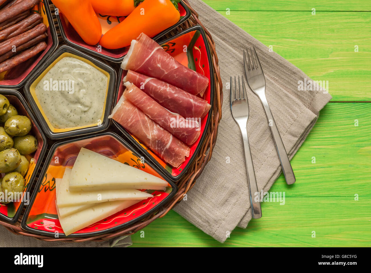 Basket with Spanish tapas on a rustic green wooden table Stock Photo ...