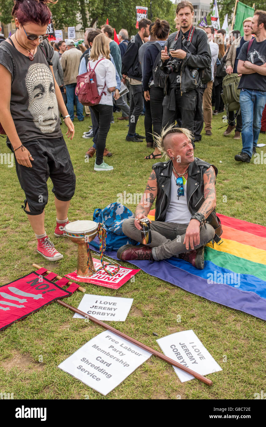 A supporter of Jeremy Corbyn resting on a rainbow flag on the grass ...