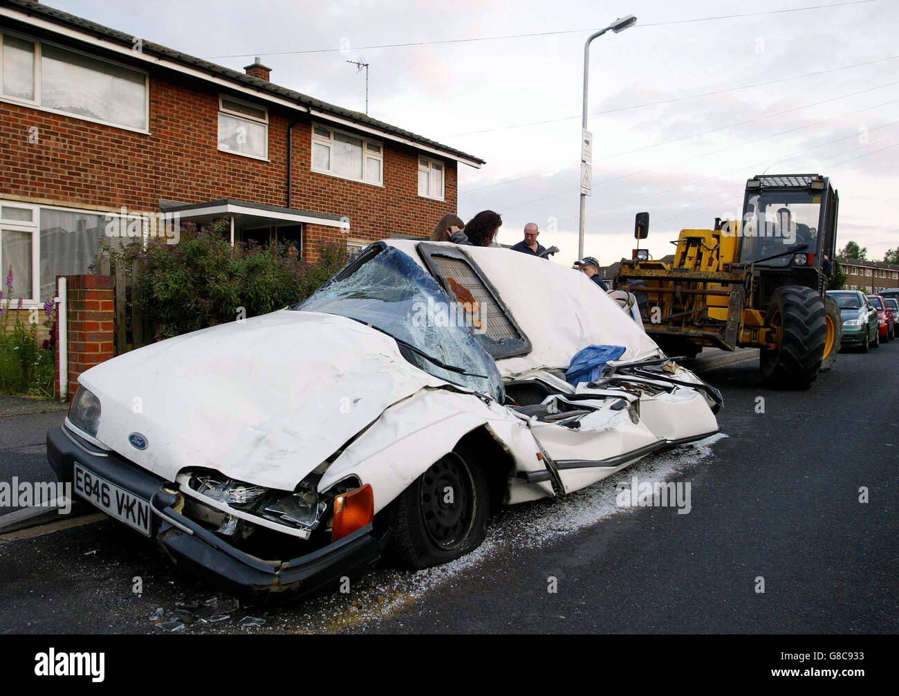 A recovery forklift removing one of the damaged cars from the scene ...