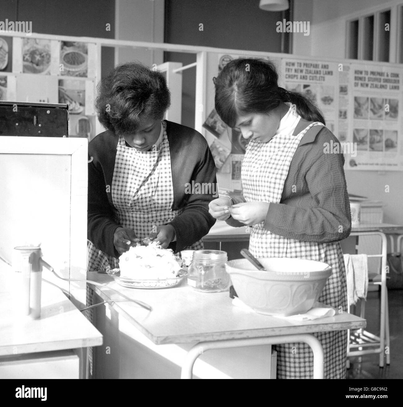 A Cypriot girl helps a West Indian prepare food in the school annex of ...