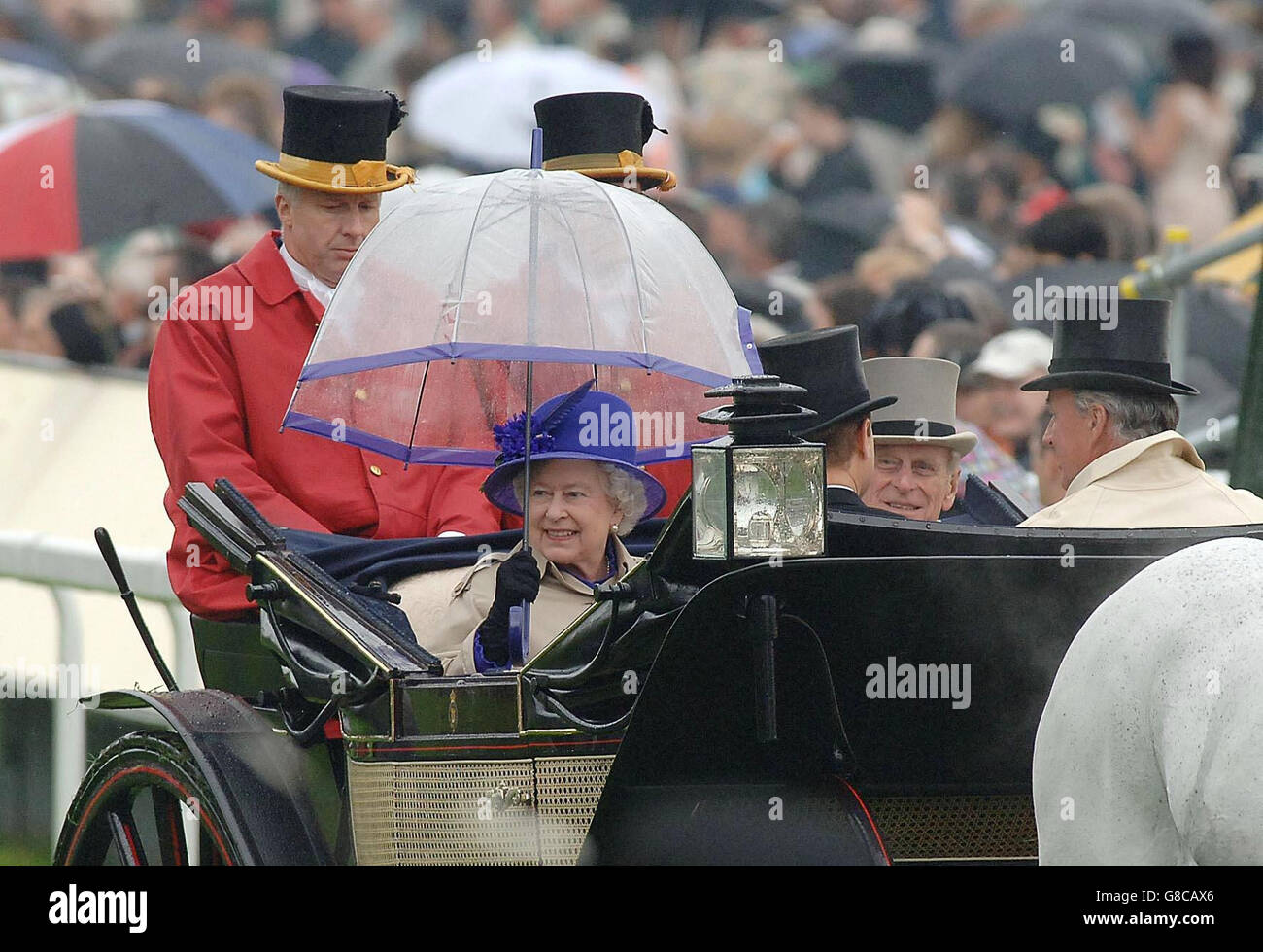 Britain's Queen Elizabeth II protects herself from the rain during the ...