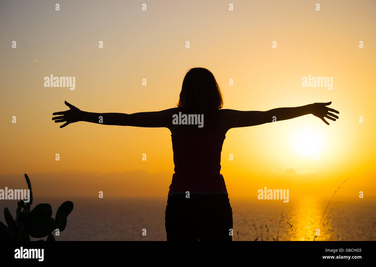 girl silhouette with open arms at sunset Stock Photo - Alamy