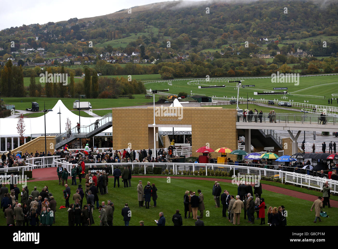 Racegoers watch the leave the parade ring at cheltenham racecourse hi ...
