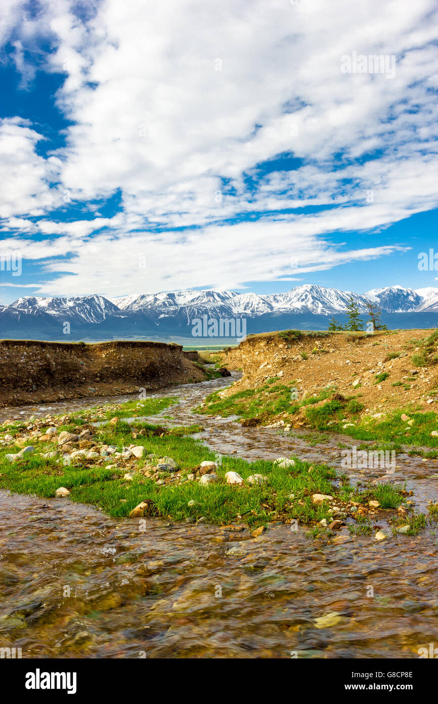 Small river with rocky shores flowing through a mountain valley Stock ...