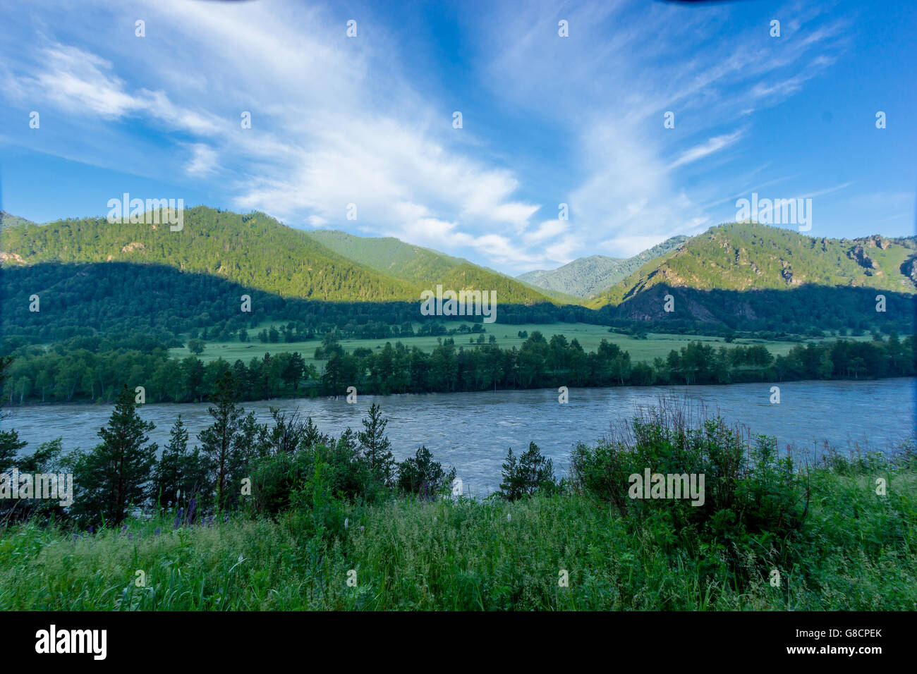 Small river with rocky shores flowing through a mountain valley Stock ...