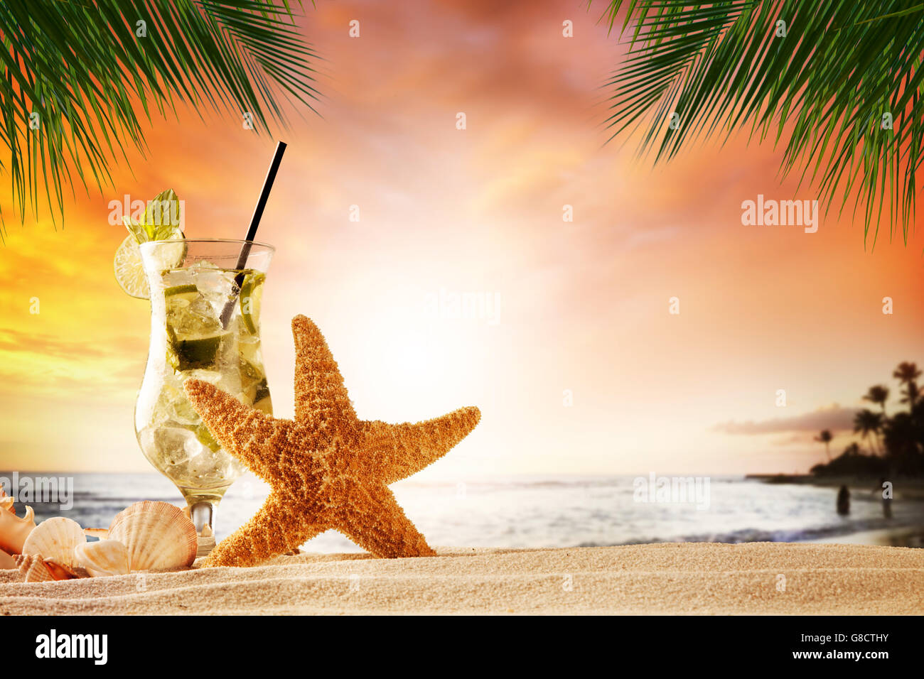 Summer cocktail with blur beach on background in sunset Stock Photo - Alamy