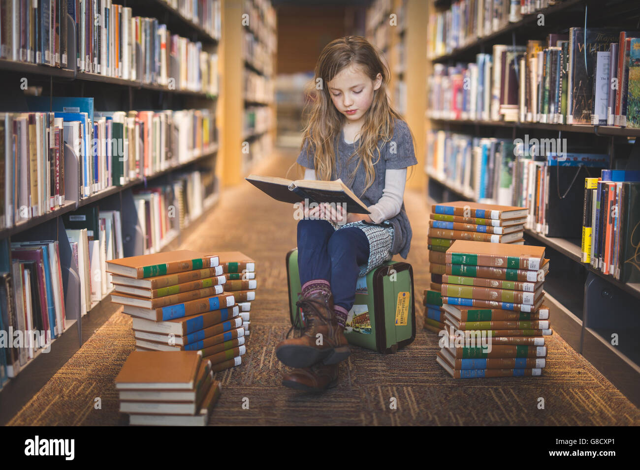 Stylish young girl reading in the library Stock Photo - Alamy