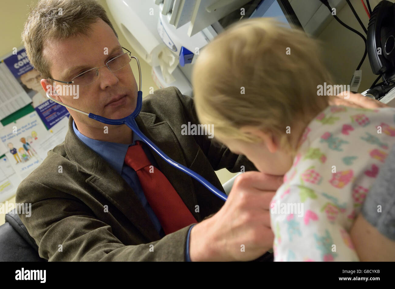 A doctor examining the health of a toddler using a stethoscope. England ...