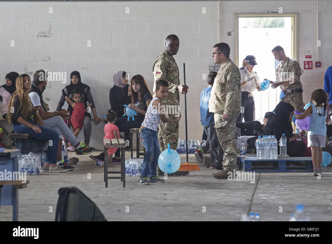 Syrian migrants are temporarily housed at a warehouse after coming ...