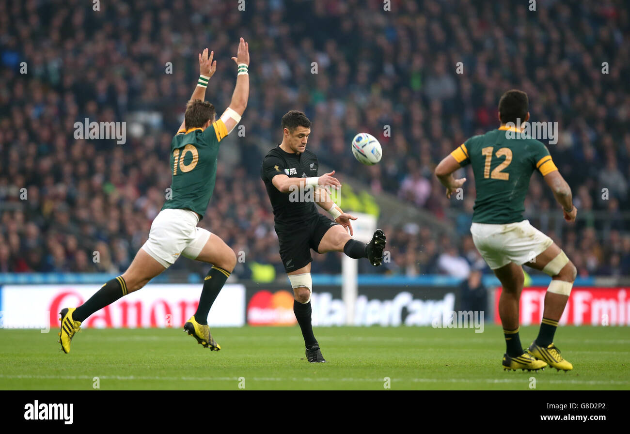 New Zealand's Dan Carter kicks the ball high away from the onrushing ...