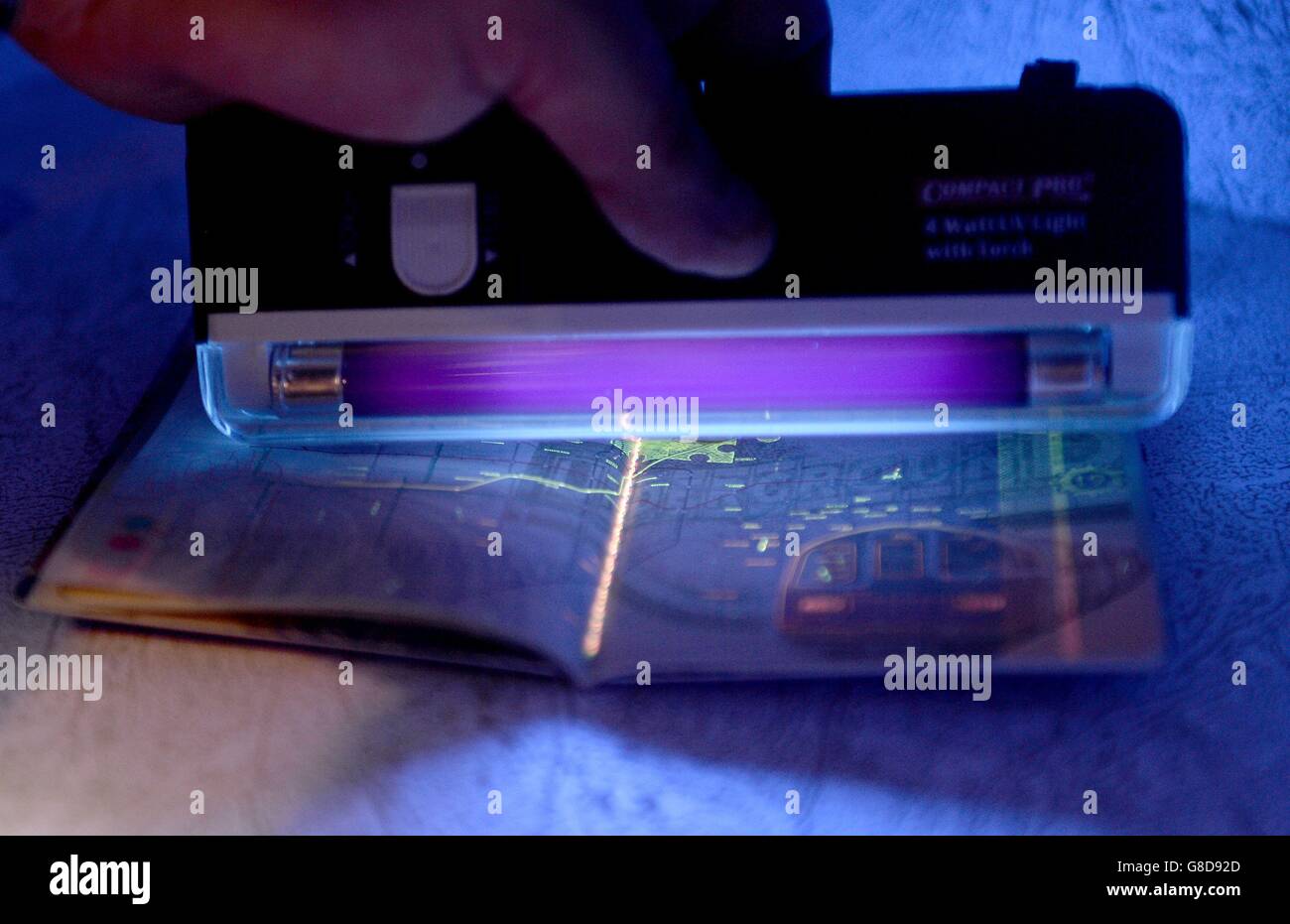 A passport is examined with an ultraviolet light at the launch of the ...