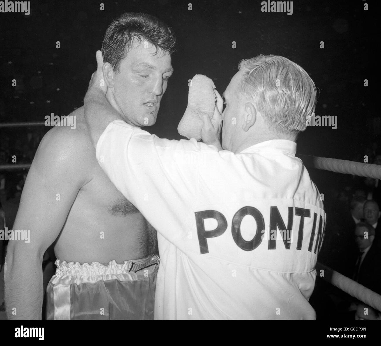 A dejected Brian London (l) gets a swab with a sponge after his knock ...