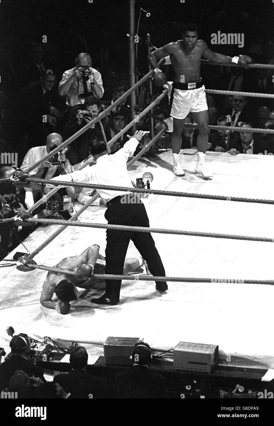 Referee Harry Gibbs spreads his arms over the prostrate Brian London ...