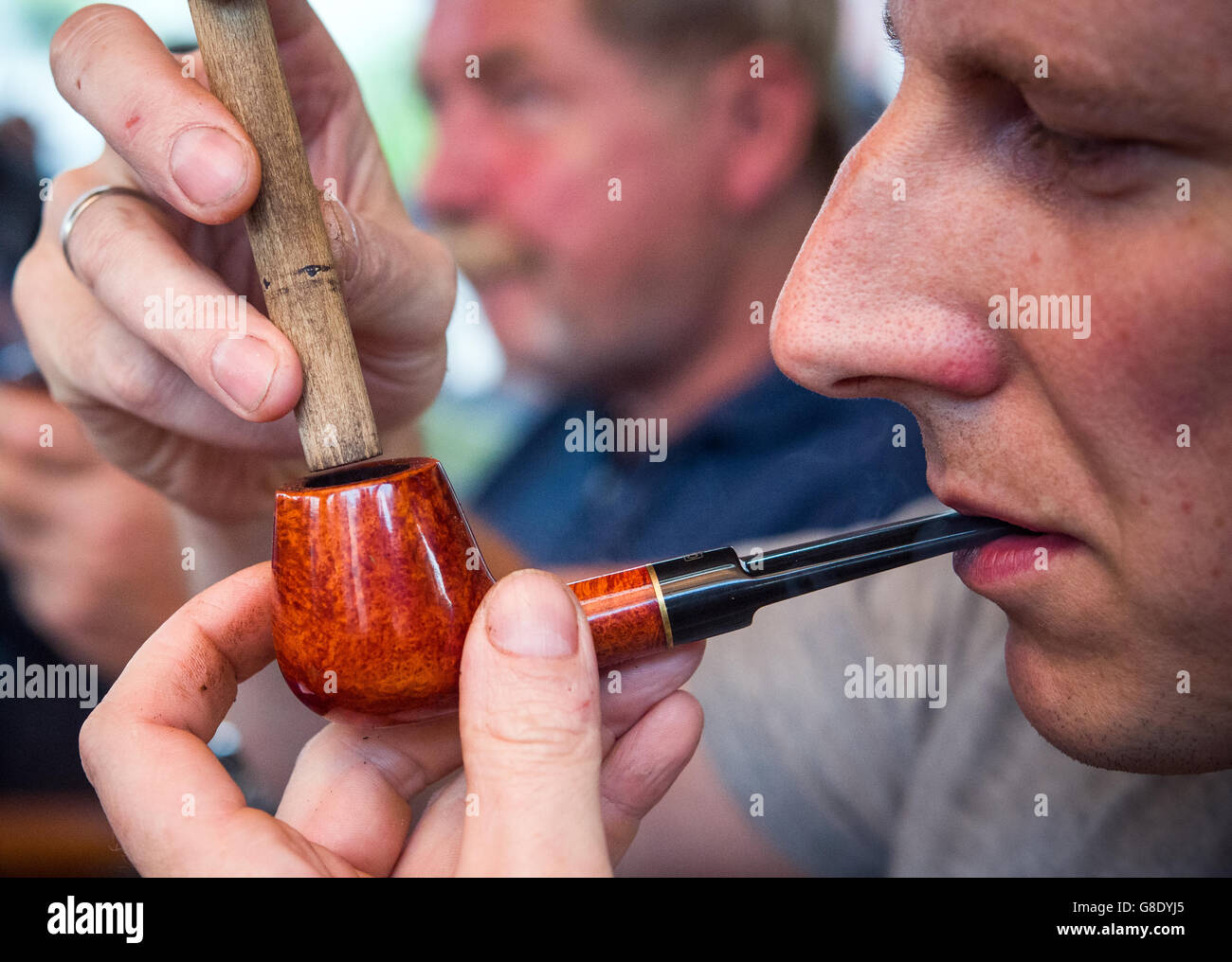 Members of the Pipe-Club-Wriezen competing in smoking a pipe as slow as ...