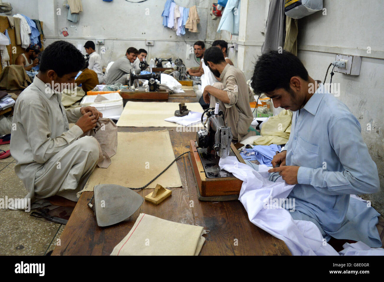 Peshawar. 28th June, 2016. Tailors stitch clothes for the upcoming Eid ...