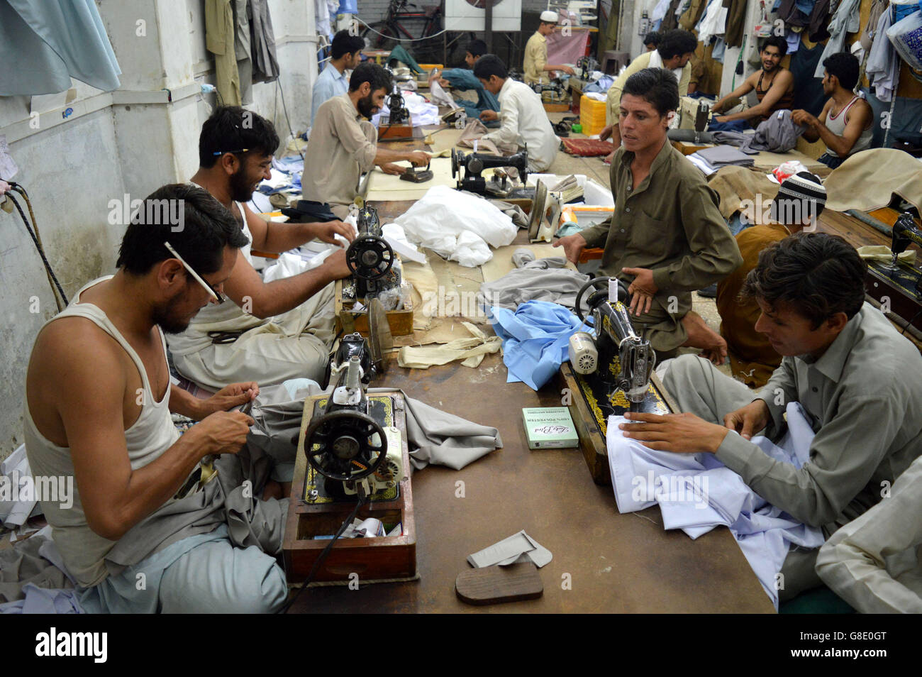 Peshawar. 28th June, 2016. Tailors stitch clothes for the upcoming Eid ...
