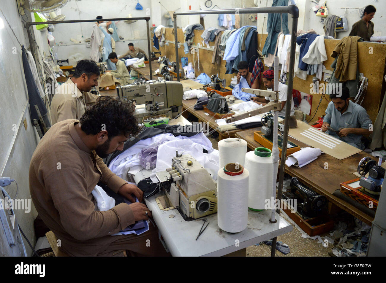 Peshawar. 28th June, 2016. Tailors stitch clothes for the upcoming Eid ...