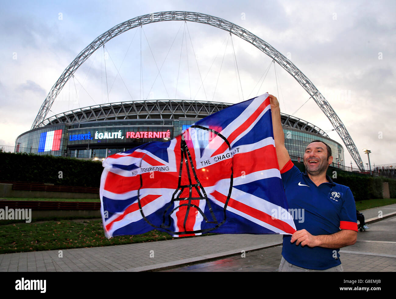 A French fan arriving early to the stadium waving a Union Jack flag ...