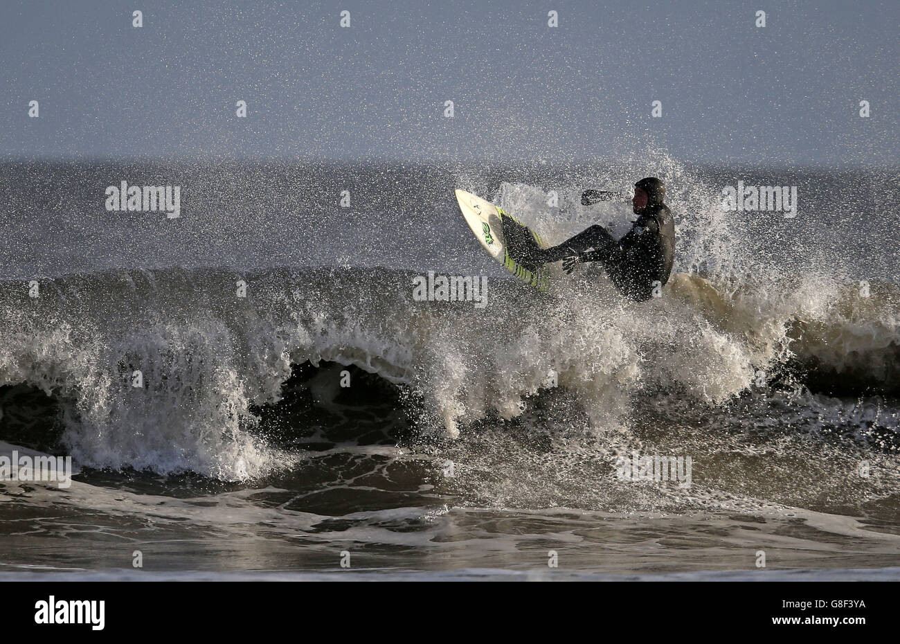 A surfer rides the waves at Tynemouth, Tyne and Wear, North Tyneside ...