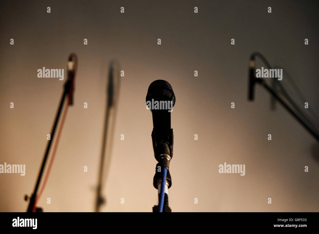 Vocal microphone and two blurred studio recording microphones with ...