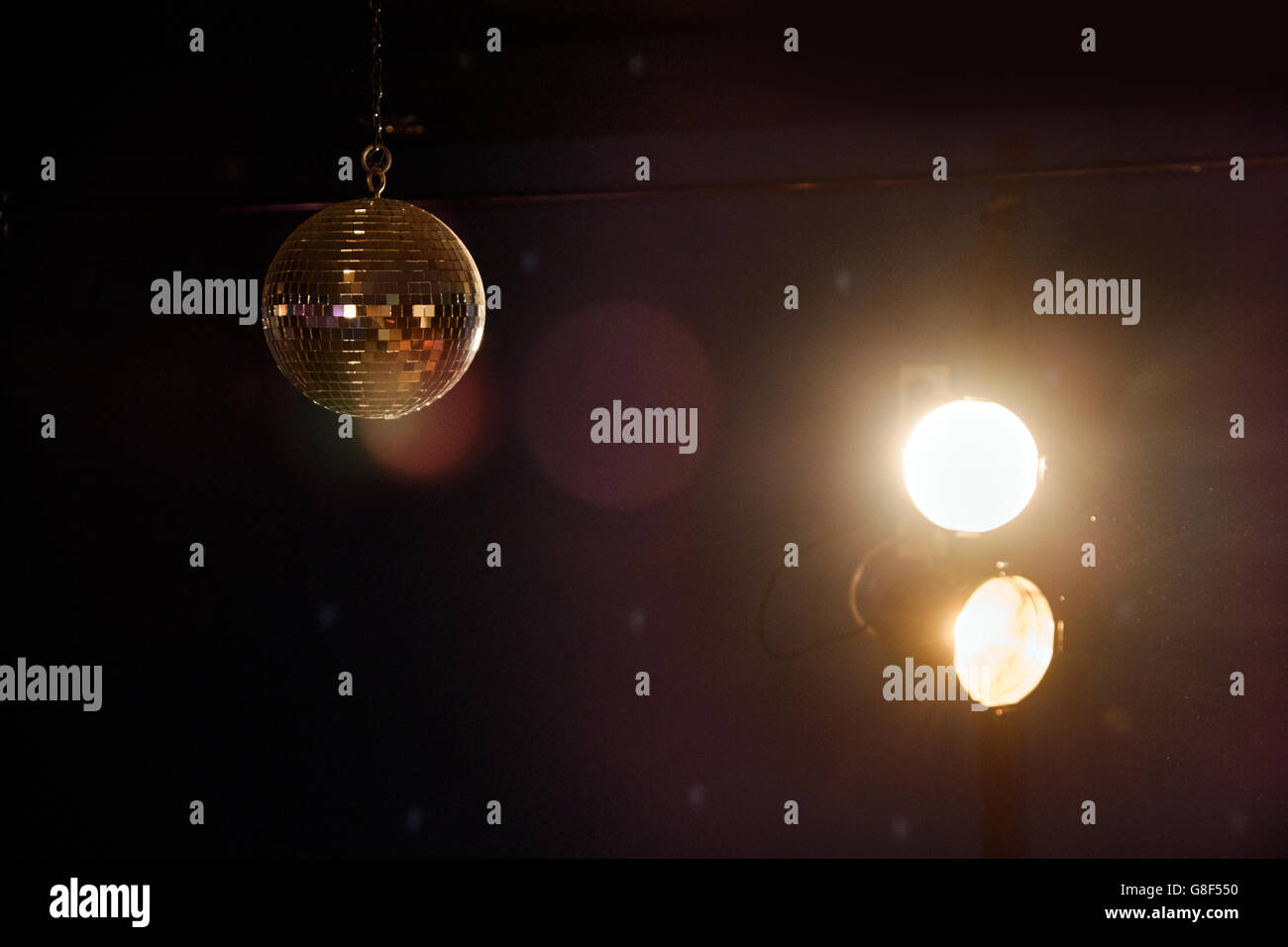 Golden mirror ball highlighted with two spotlights shining in the ...
