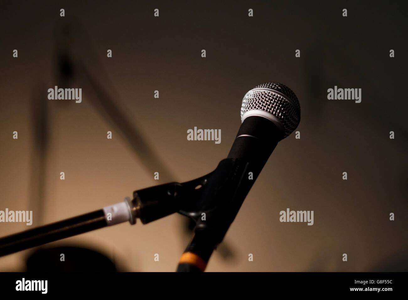 Vocal microphone with stand on the stage with shadows on highlighted ...