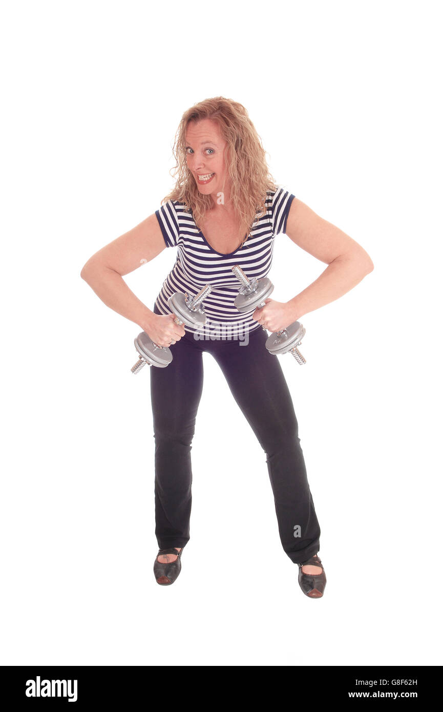 A smiling meddle age woman working out with two dumbbells, standing ...