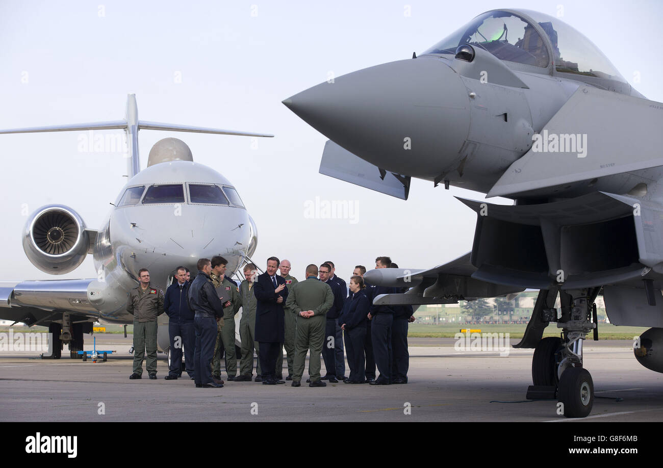 British Prime Minister David Cameron (centre) talks with military ...