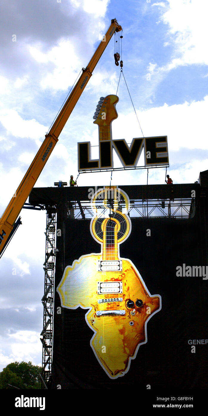 A sign is hoisted into position, as work begins on the Live8 stage ...