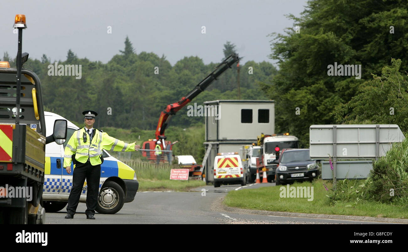 A police officer stops traffic as a temporary building is lowered into ...