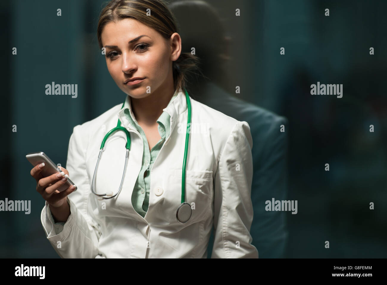 Portrait Of A Young Beautiful Female Doctor Writing Text On Mobile