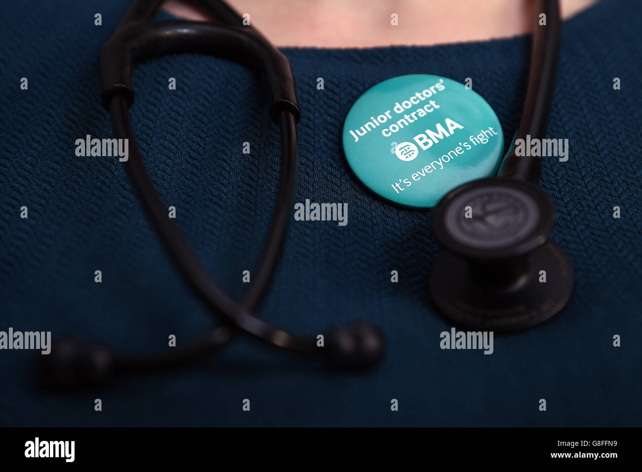 A doctor wears a badge next to her stethoscope in support of the Junior ...
