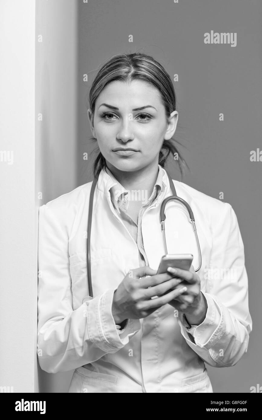 Portrait Of A Young Beautiful Female Doctor Writing Text On Mobile