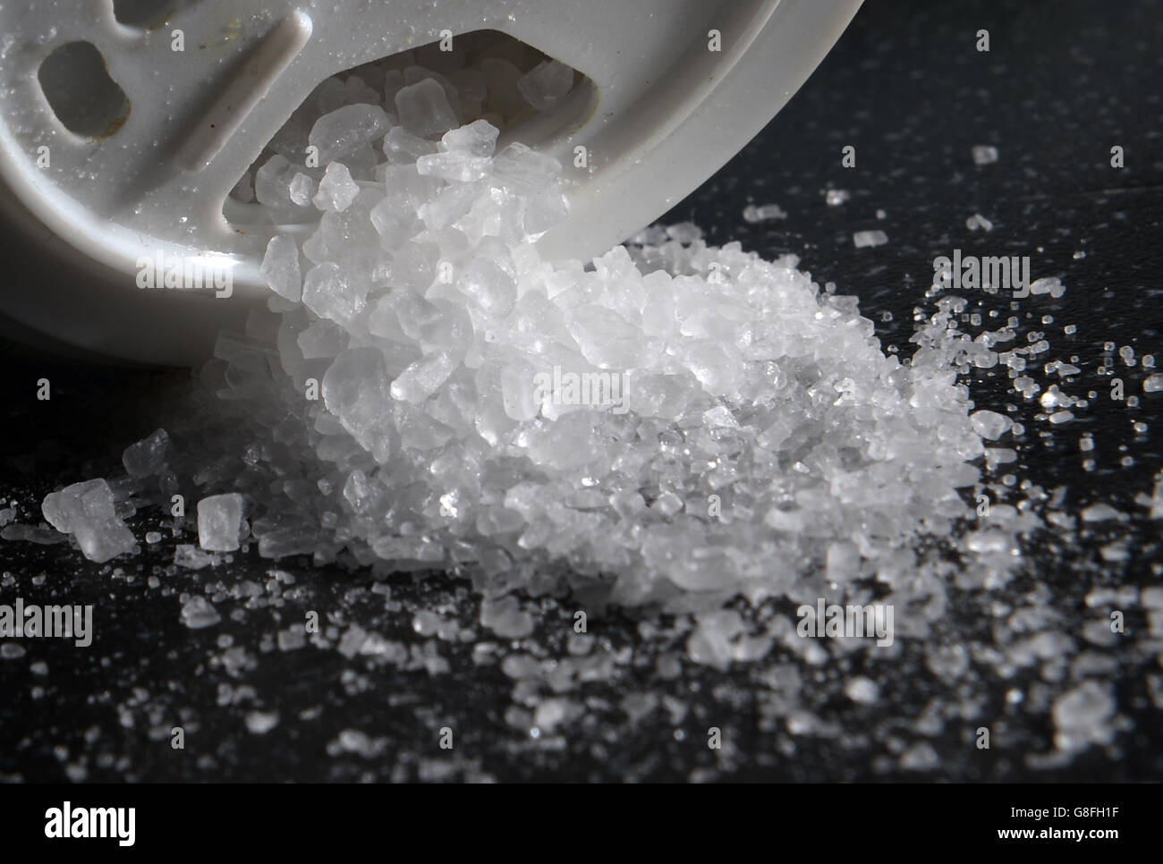 Sea salt is poured from a salt shaker hi-res stock photography and ...