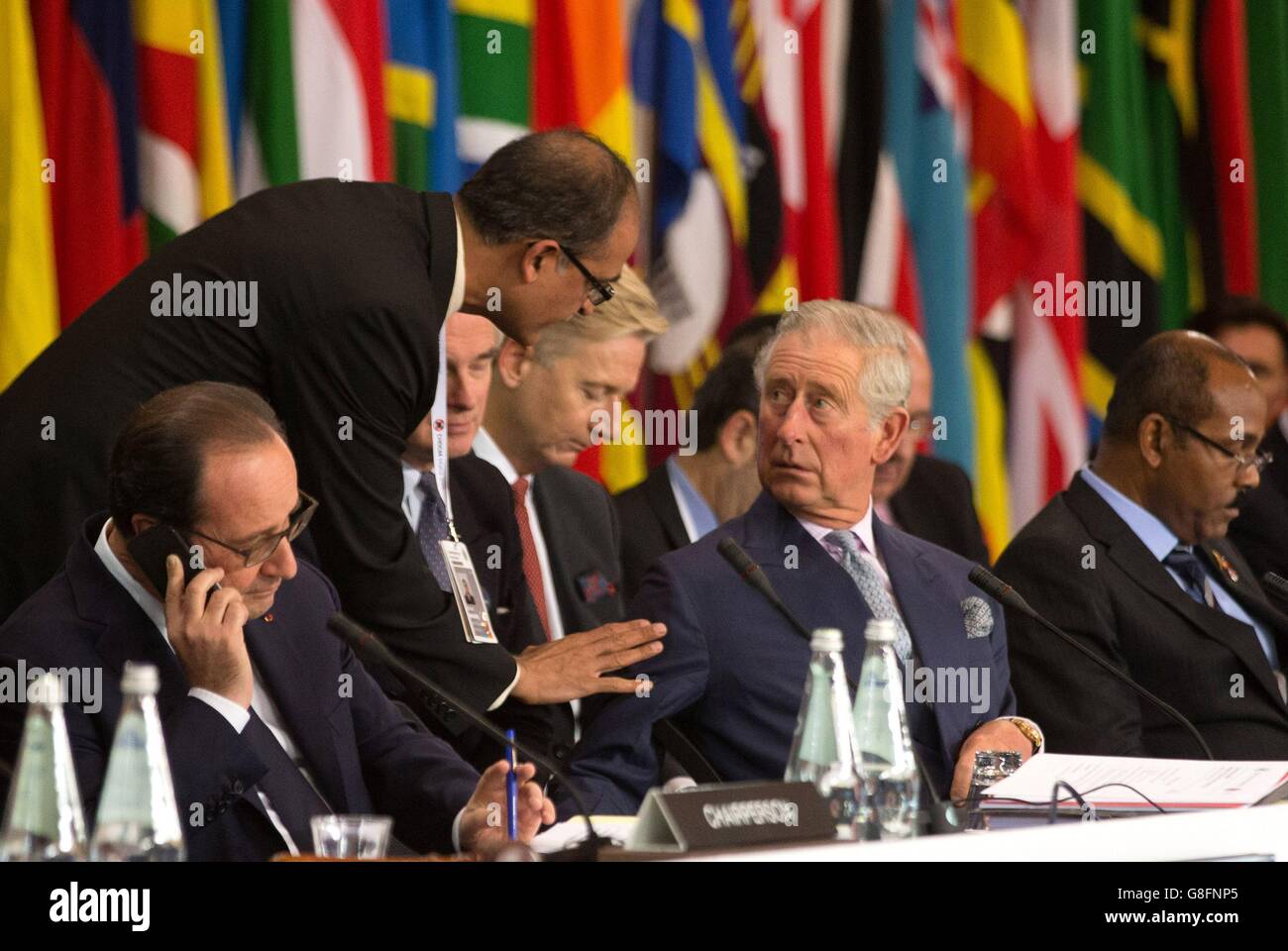 French President Francois Hollande takes a telephone call as he sits ...